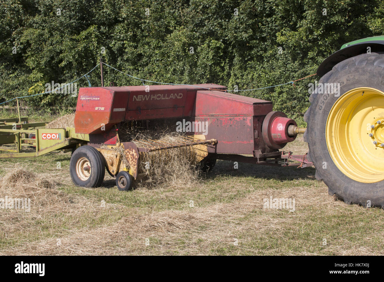 Haymaking, third stage, tractor towing conventional baler and bale ...