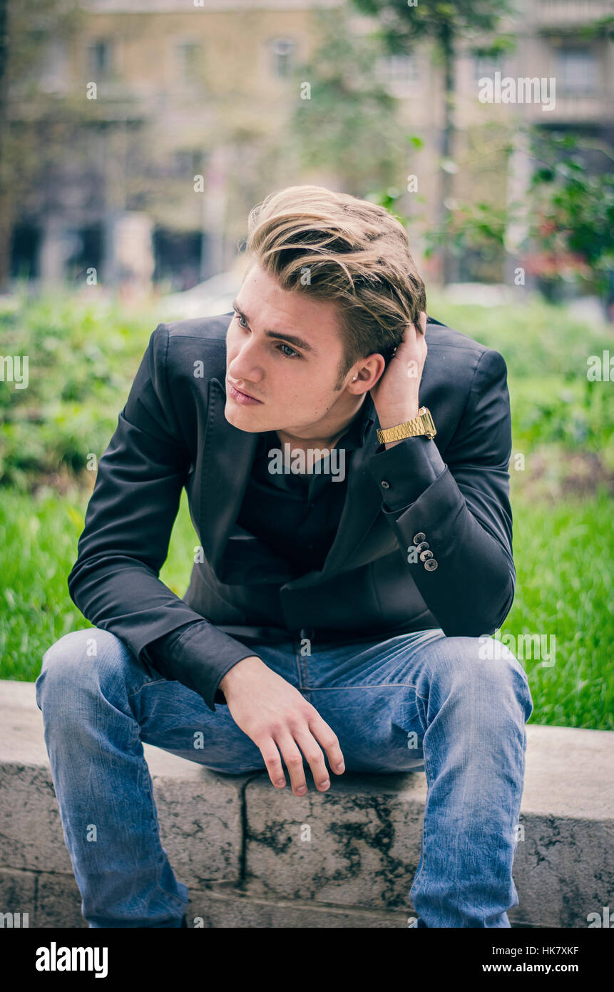 Depressed Young White Man Sitting at Street Side Stock Photo - Alamy