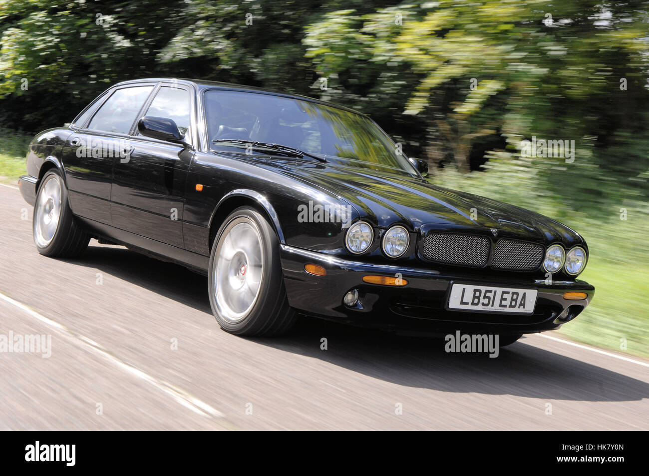 Jaguar XJR100 action shot driving on road Stock Photo - Alamy