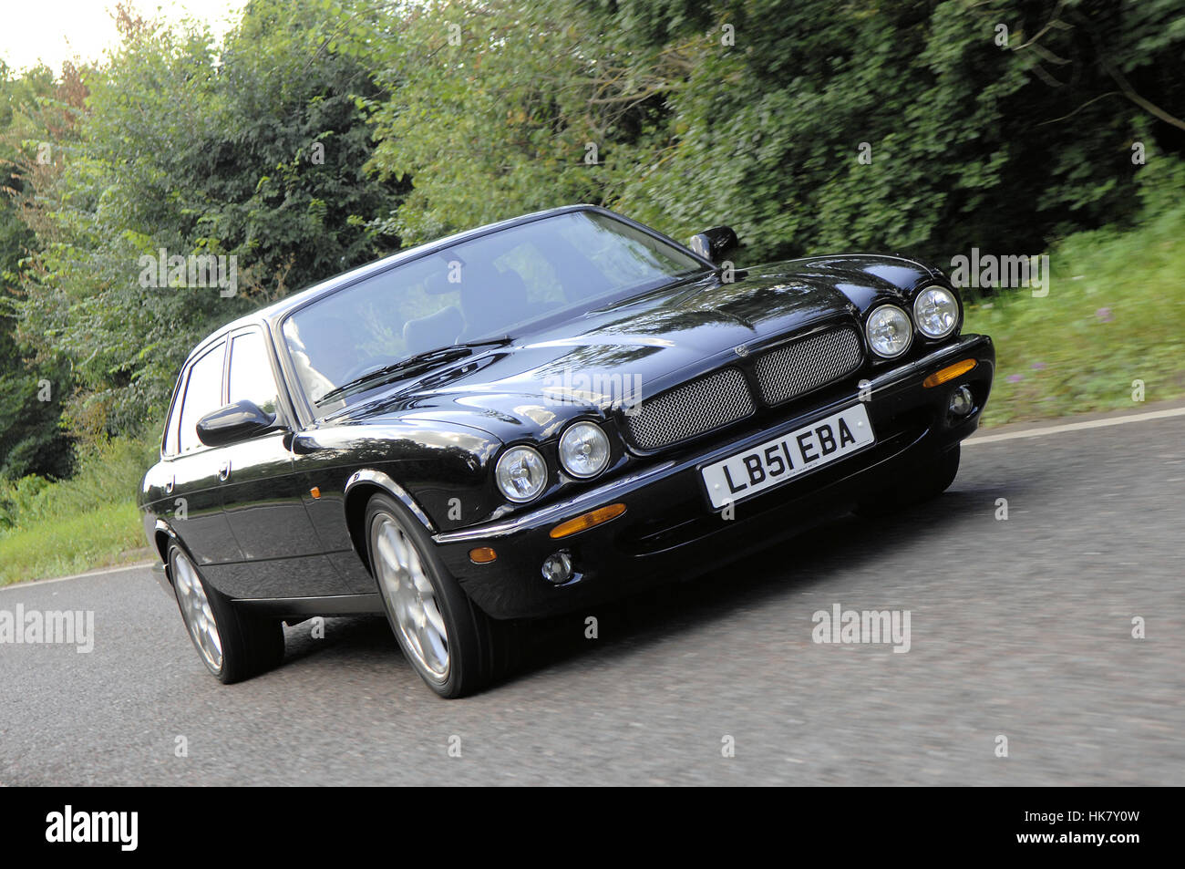 Jaguar XJR100 action shot driving on road Stock Photo - Alamy