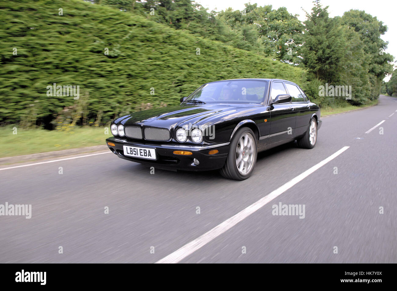 Jaguar XJR100 action shot driving on road Stock Photo - Alamy