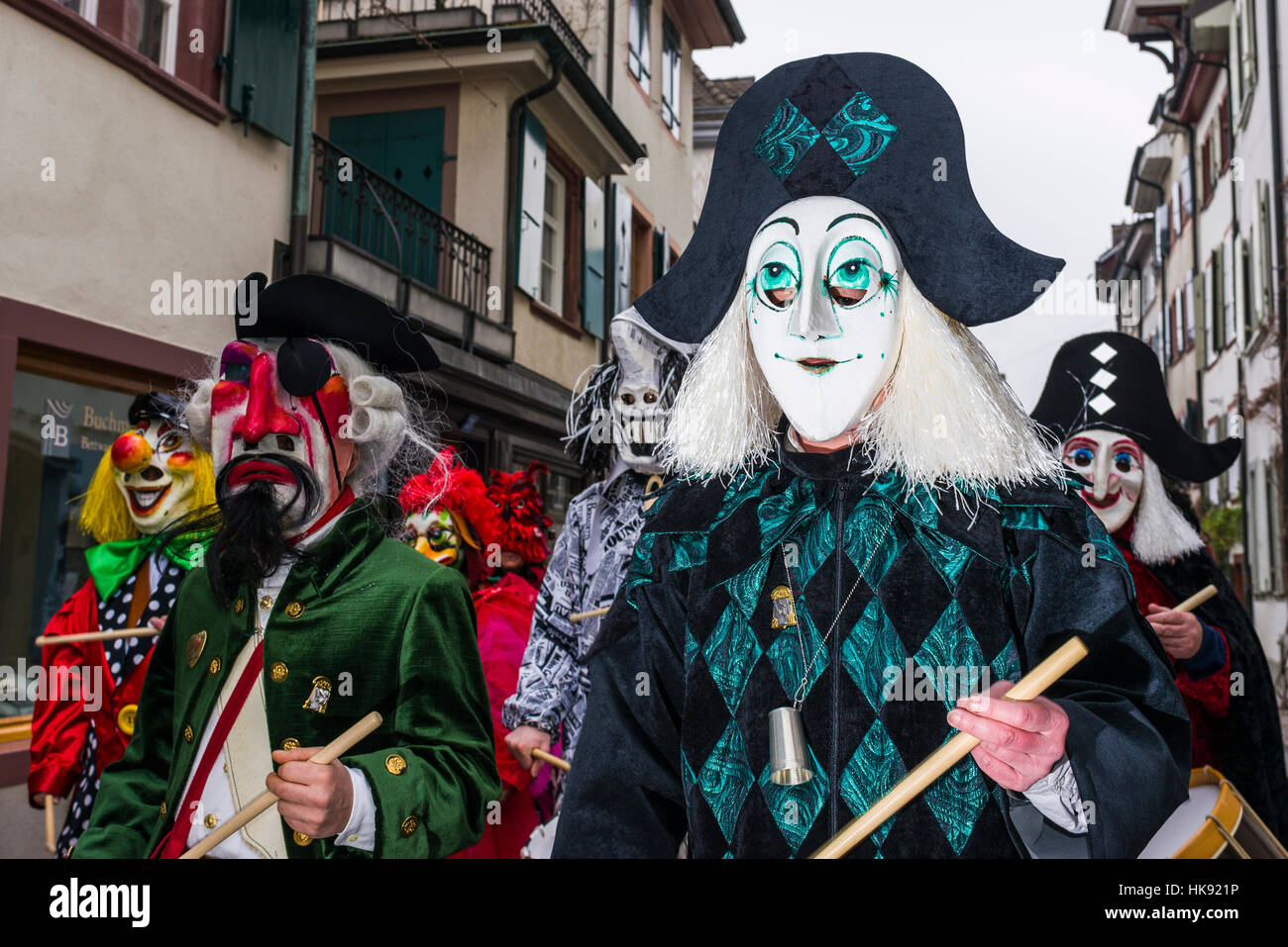 Many different groups of masked people walk through the streets of ...