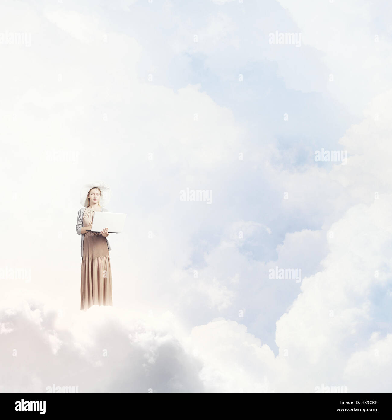 Young lady in hat and long dress using laptop hi-res stock photography ...