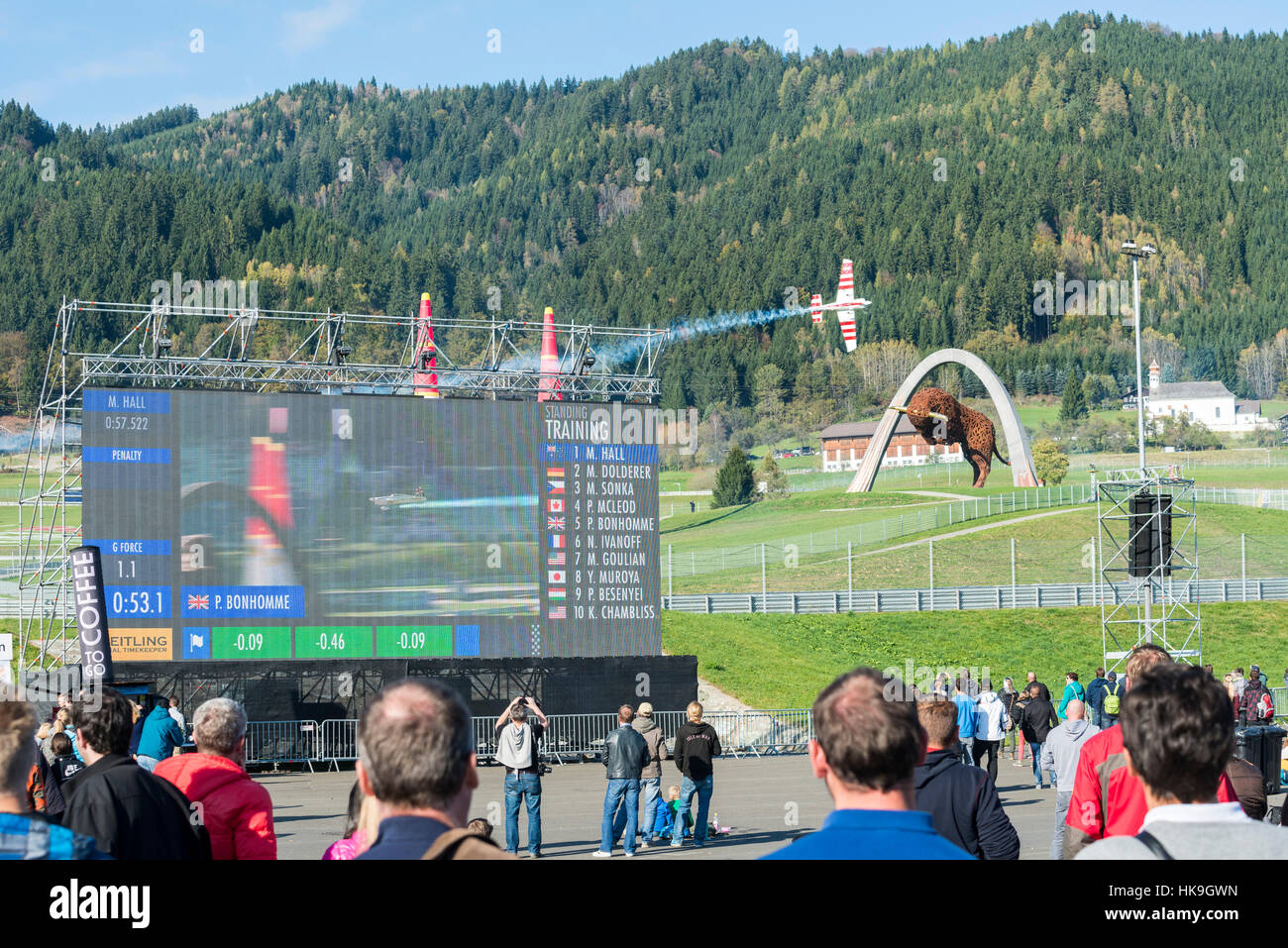 A stunt flying aeroplane, releasing smoke, is flying vertically around ...