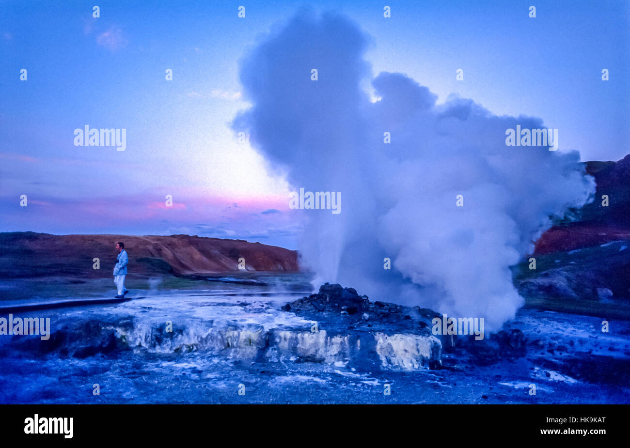 Tourists visiting geysers at nighttime on midsummer's night in Iceland ...
