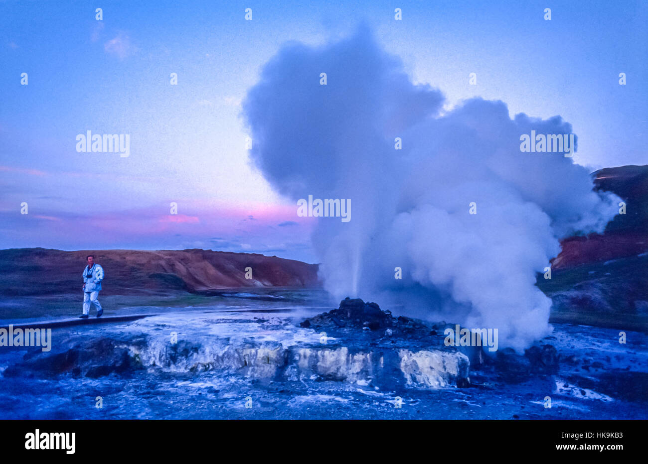 Tourists visiting geysers at nighttime on midsummer's night in Iceland ...