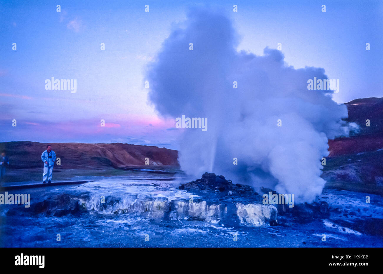Tourists visiting geysers at nighttime on midsummer's night in Iceland ...