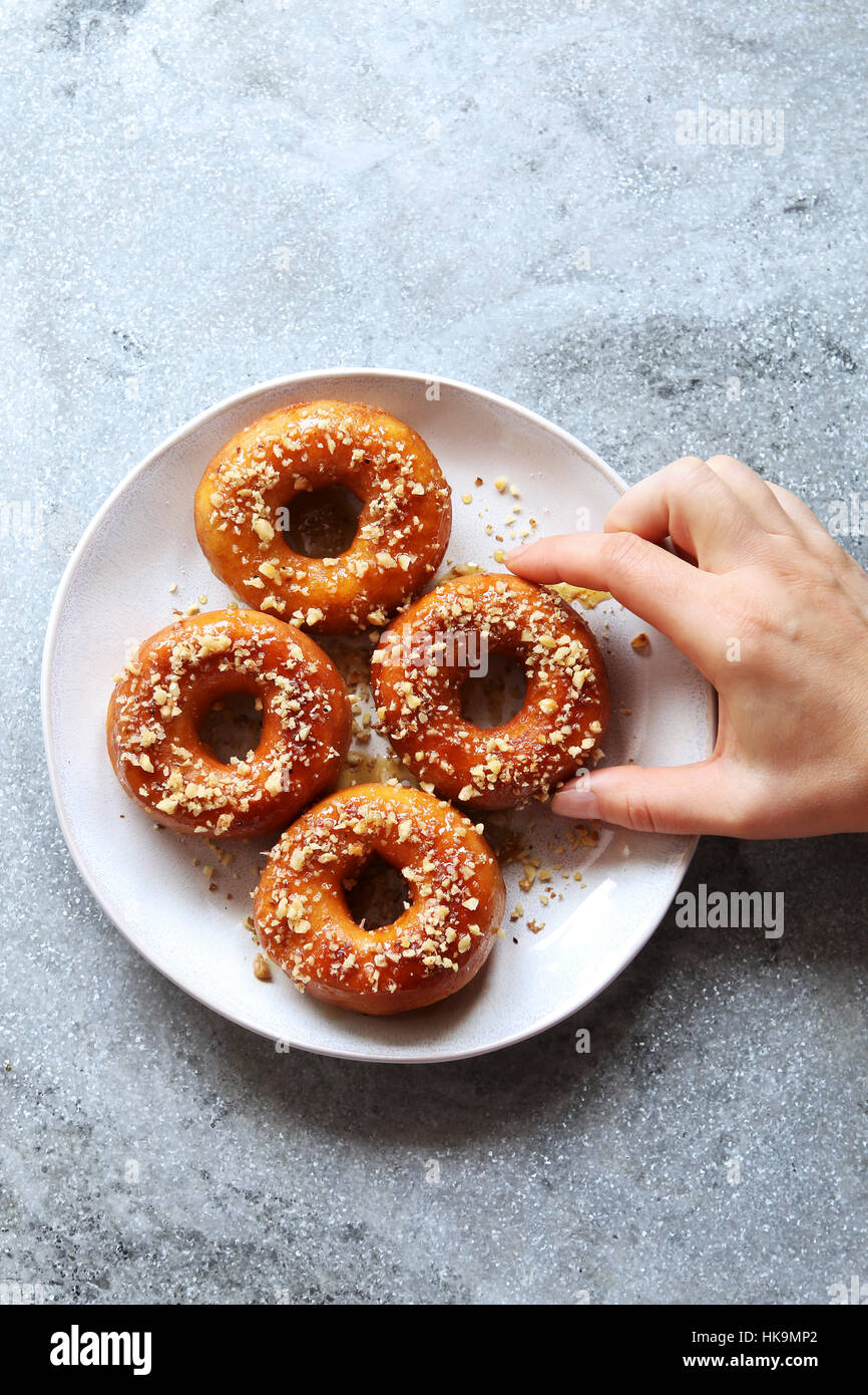 Hand grabbing donut hi-res stock photography and images - Alamy