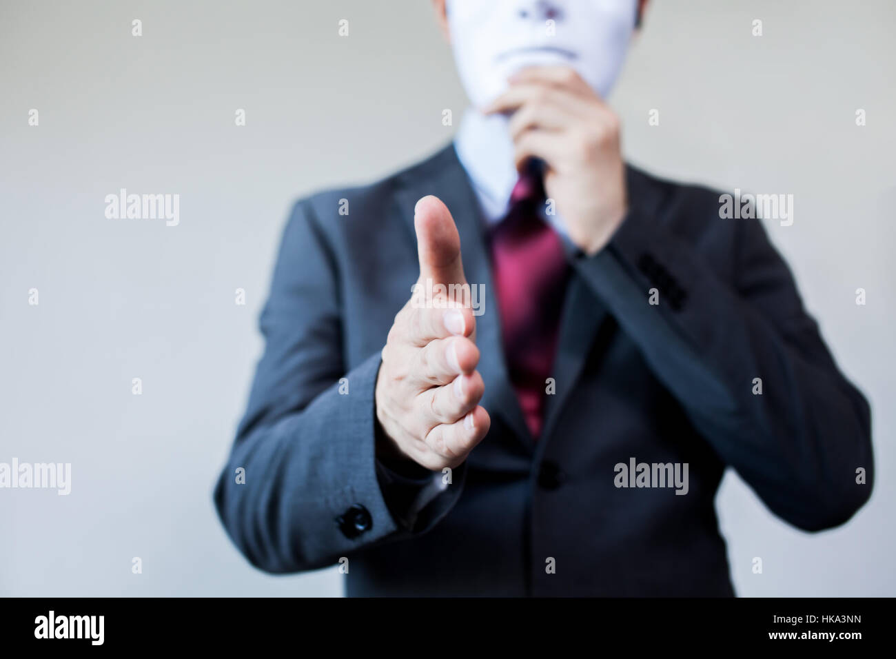Business man giving dishonest handshake hiding in the mask - Business ...