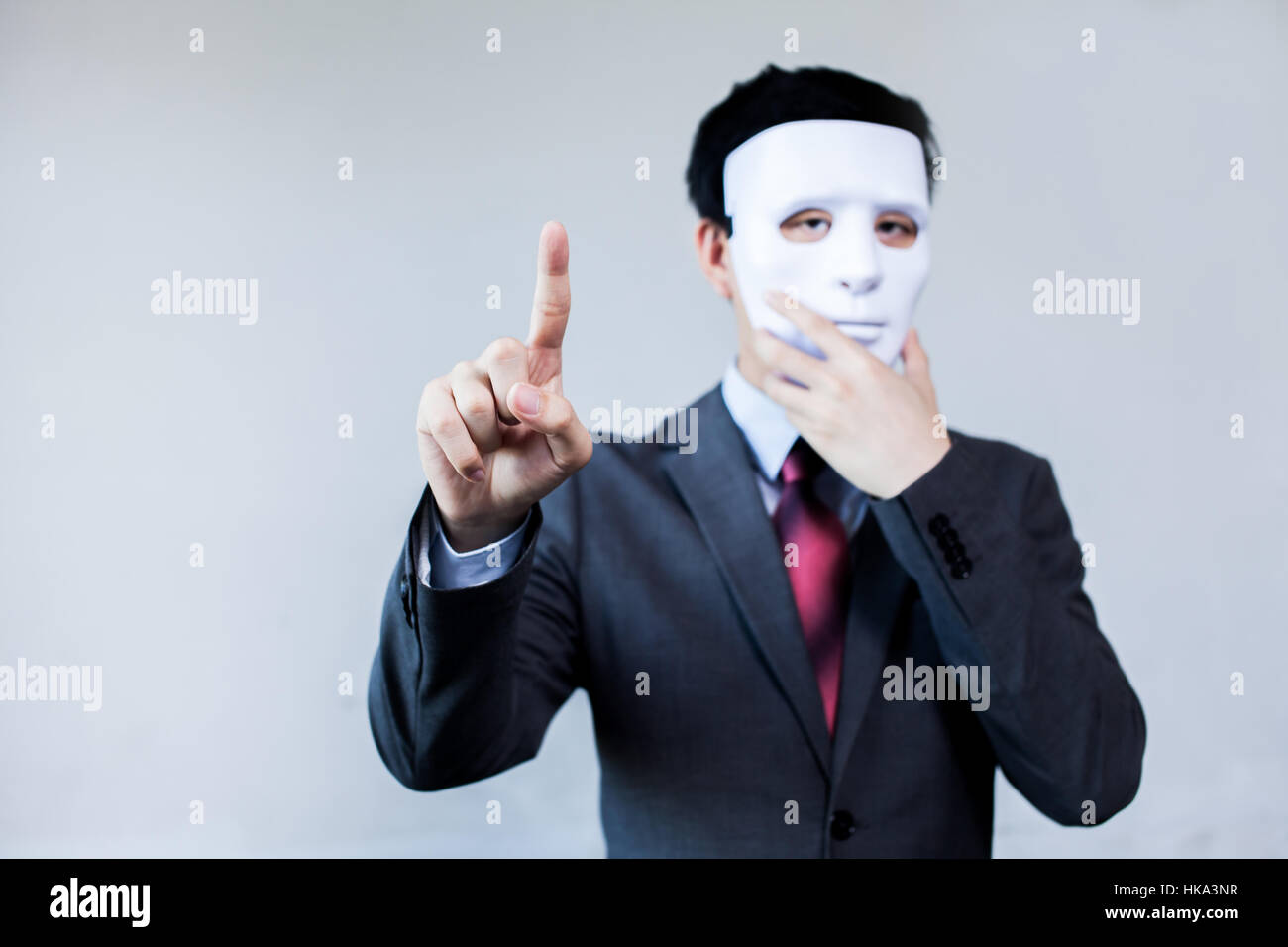 Anonymous businessman in mask hiding himself touching on virtual screen ...