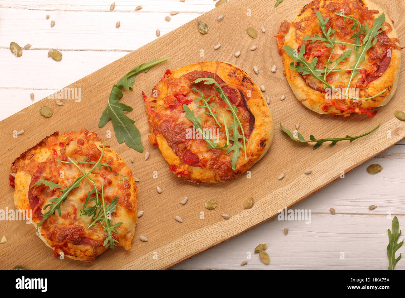 Small Pizza with mozzarella Cheese, ham and arugula Stock Photo - Alamy
