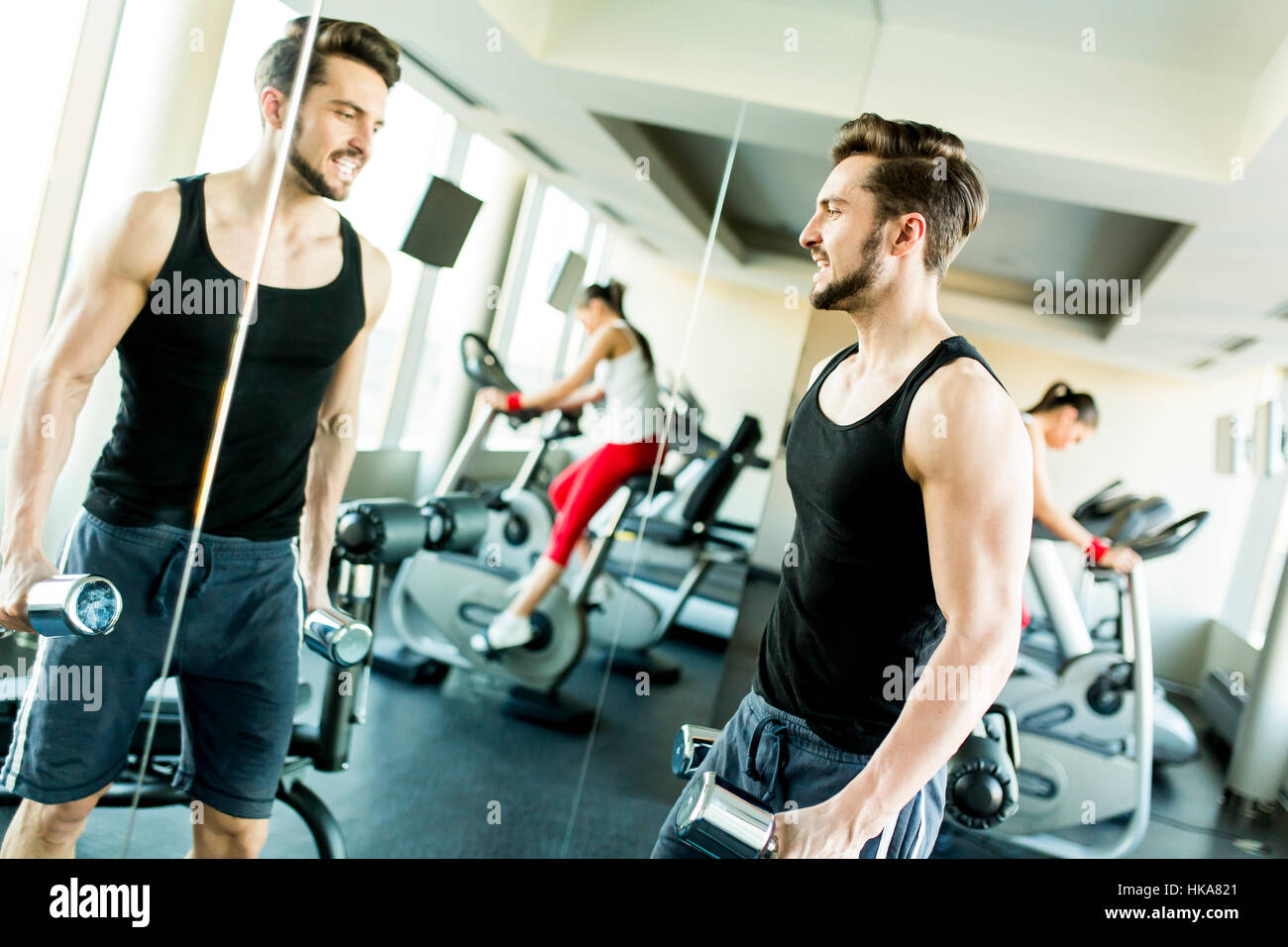 Muscular man training with red dumbbell in the gym Stock Photo - Alamy