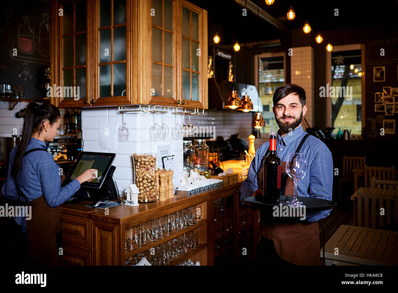 The waiter, sommelier, bartender with beard carrying a tray wi Stock ...