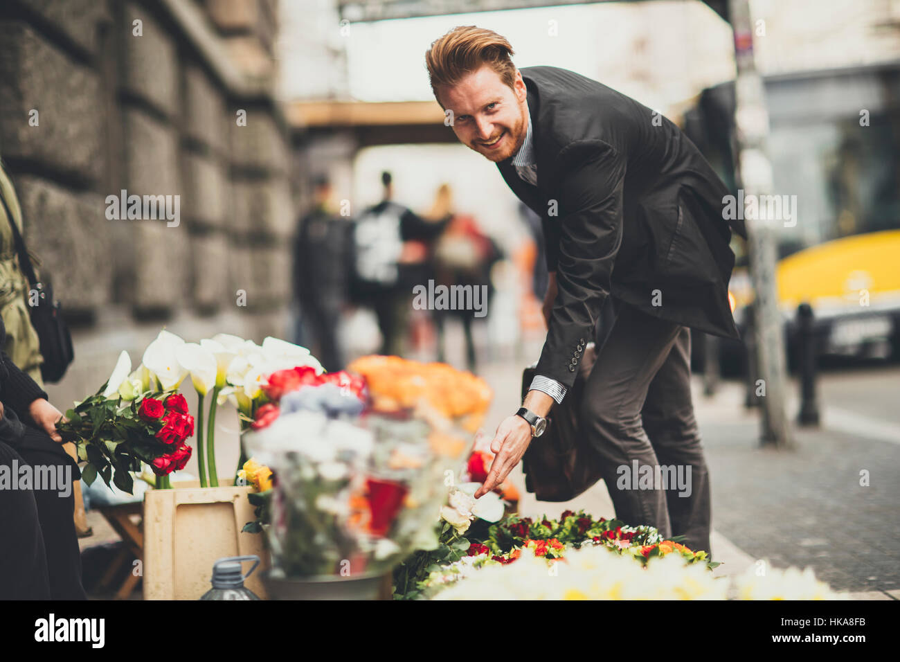 Young man buys flowers from street vendors Stock Photo - Alamy