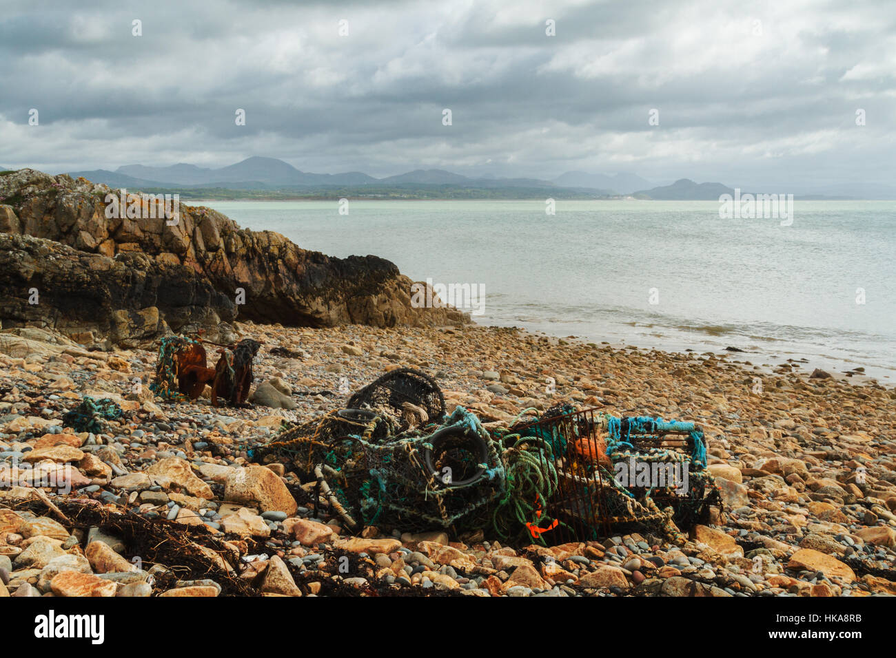 Discarded plastics, lobster pots, fishing nets on a beach at the Llyn ...