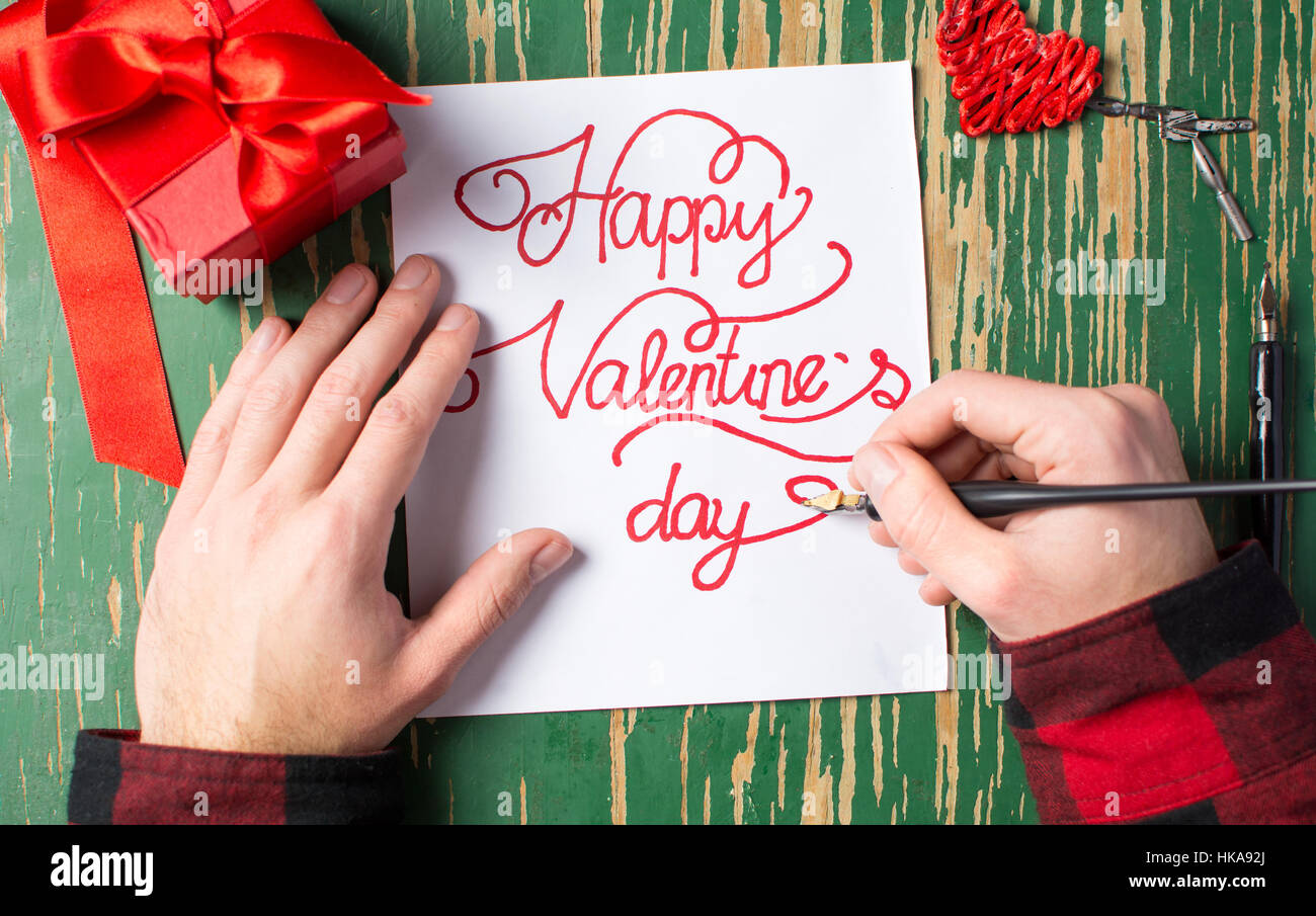 Man writing a Valentines day card and preparing a present Stock Photo ...
