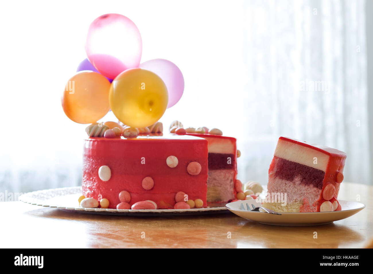 Homemade red birthday cake with air baloons. Slice of a red velvet cake ...