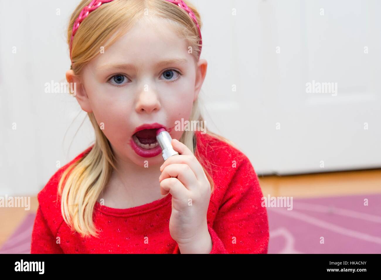 adorable school age girl putting on lipstick makeup Stock Photo - Alamy