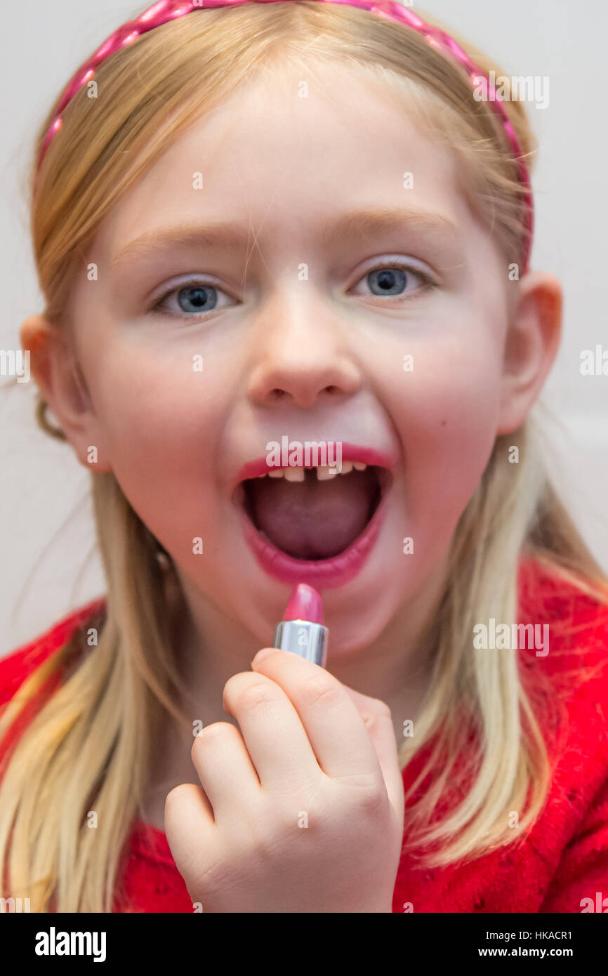 adorable school age girl putting on lipstick Stock Photo - Alamy