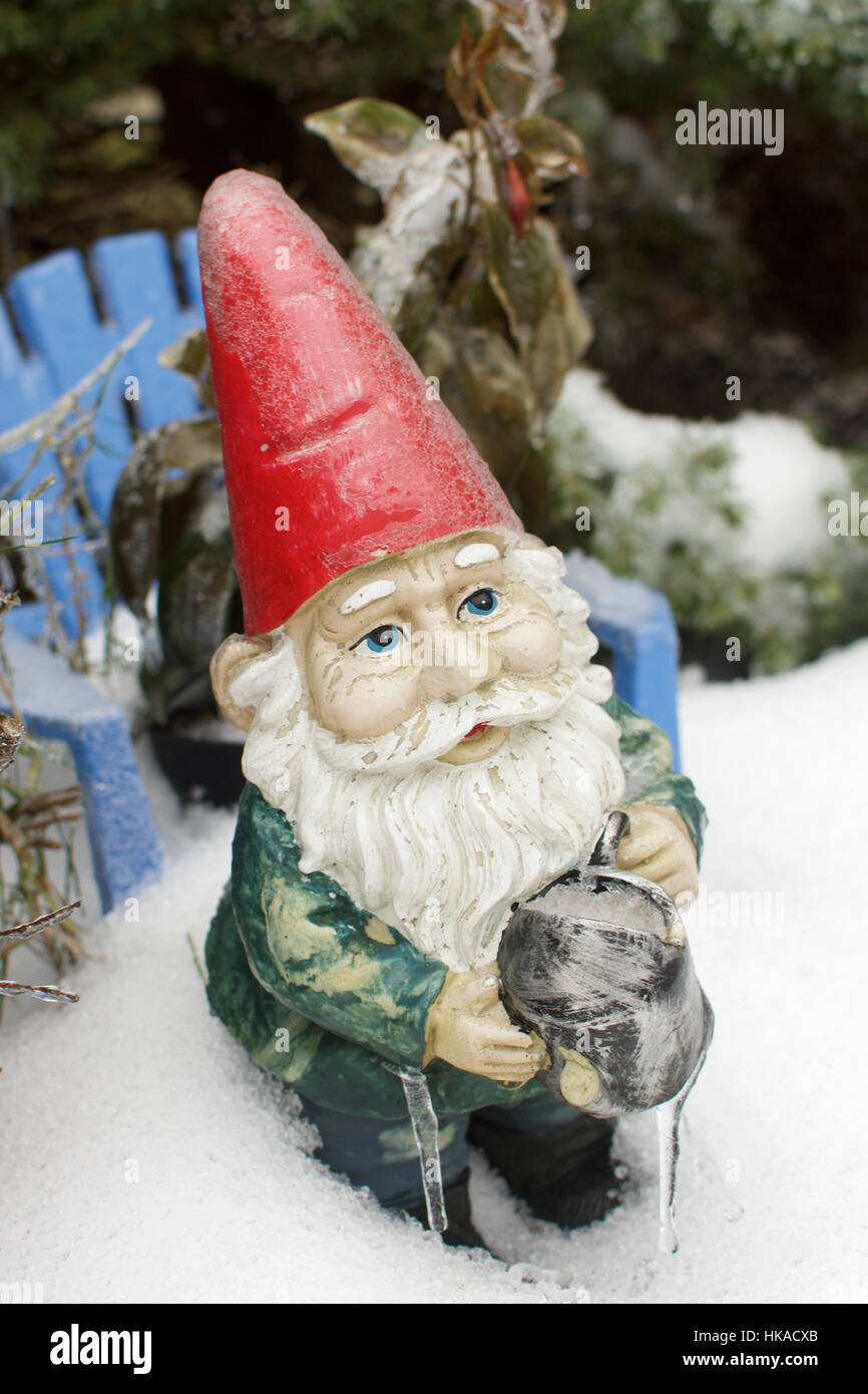 garden gnome sitting outside in freezing snow Stock Photo - Alamy