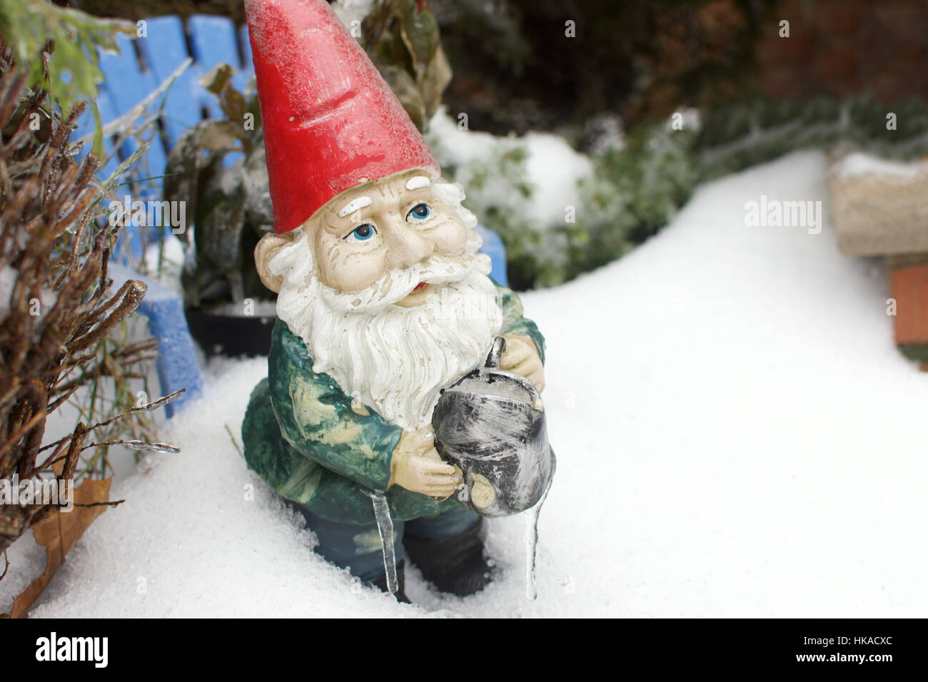 garden gnome sitting outside in freezing snow Stock Photo - Alamy