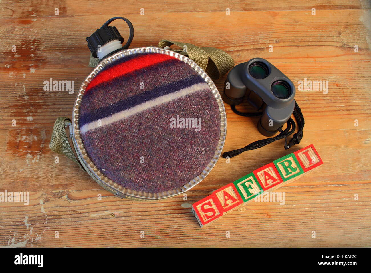 Water bottle and binoculars on a wooden surface image in landscape ...