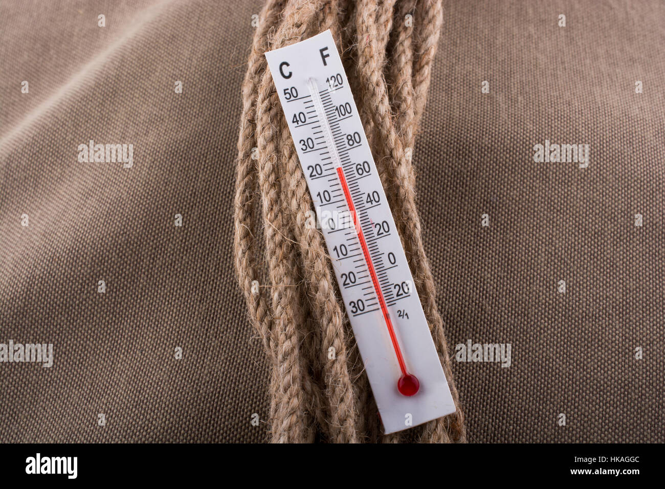 Thermometer placed on a brown rope on a fabric background Stock Photo ...