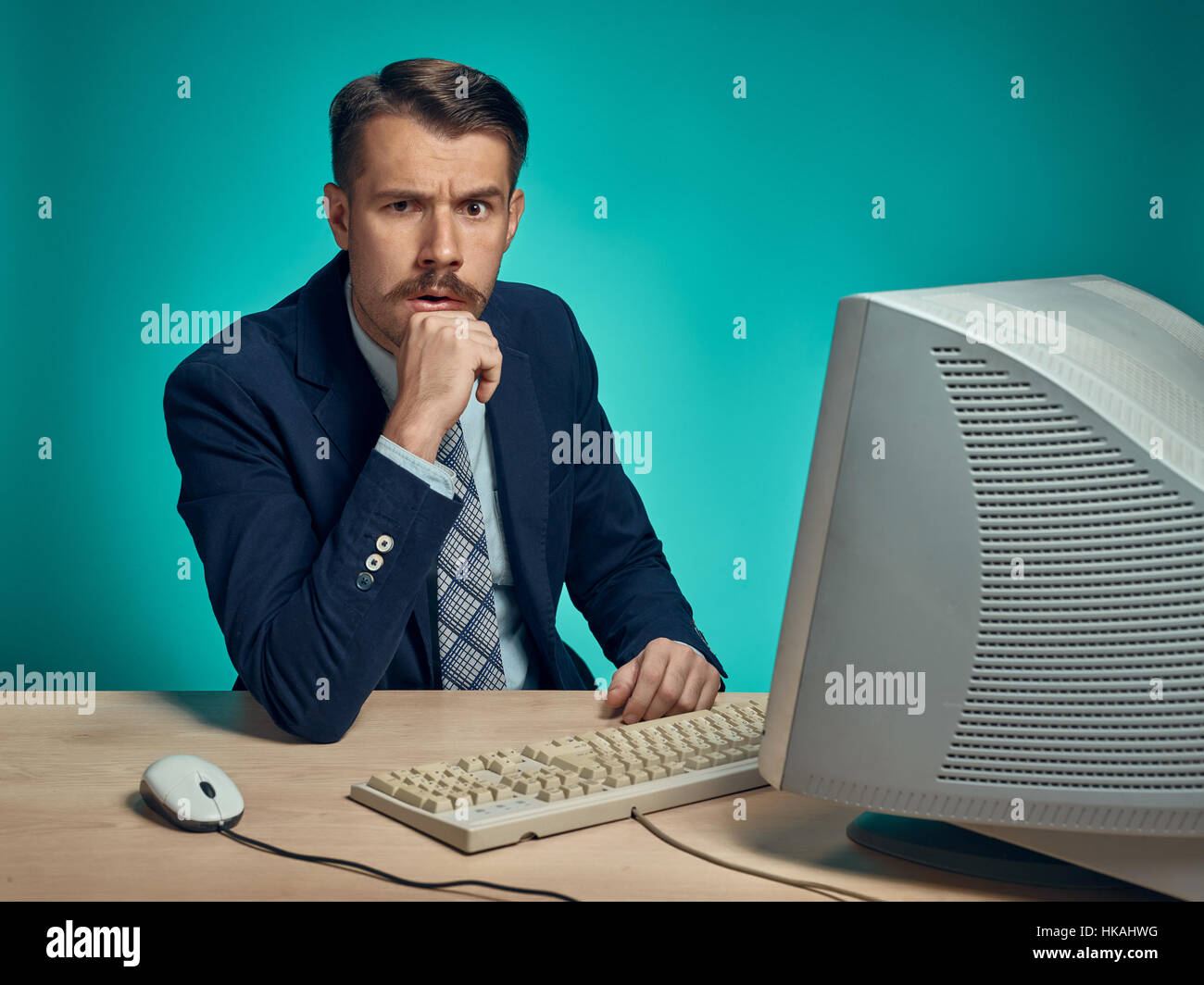 Surprised Young Man Working On computer At Desk Stock Photo - Alamy