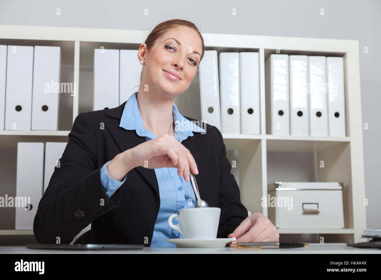 Manager sits at her desk having a coffee break Stock Photo - Alamy