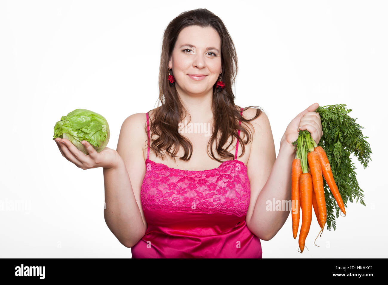 Overweighted woman with lettuce and carrots Stock Photo - Alamy