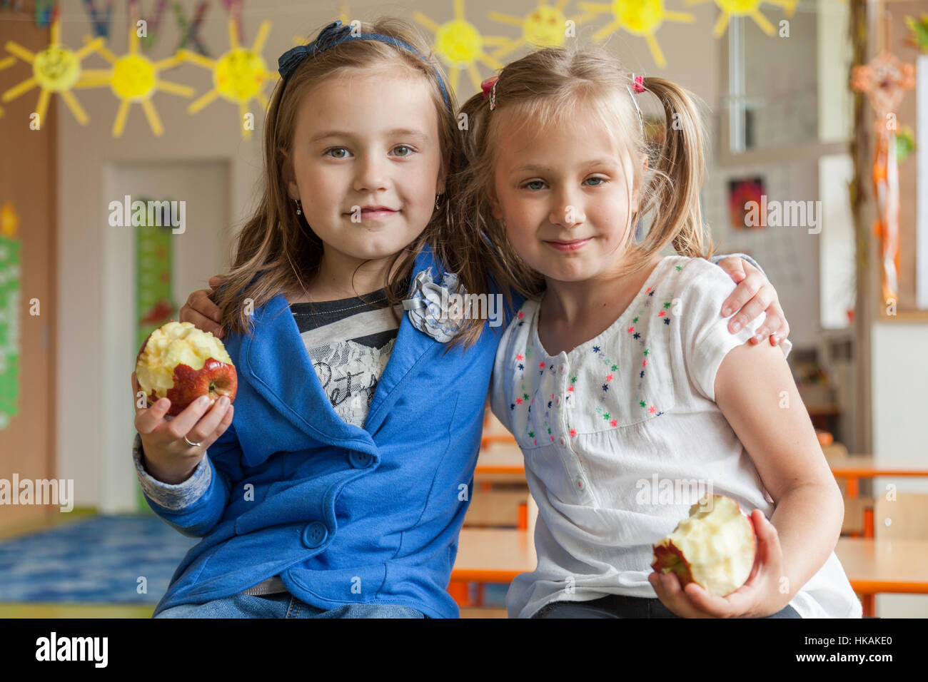 Primary school pupils eating apples in a classroom Stock Photo - Alamy