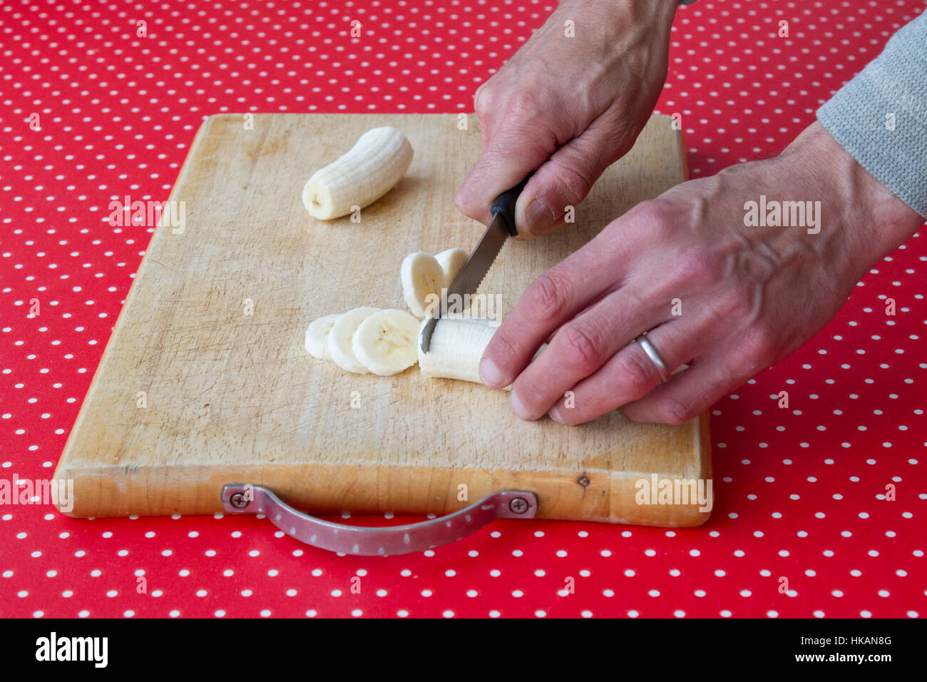 Slicing a banana on a chopping board Stock Photo - Alamy