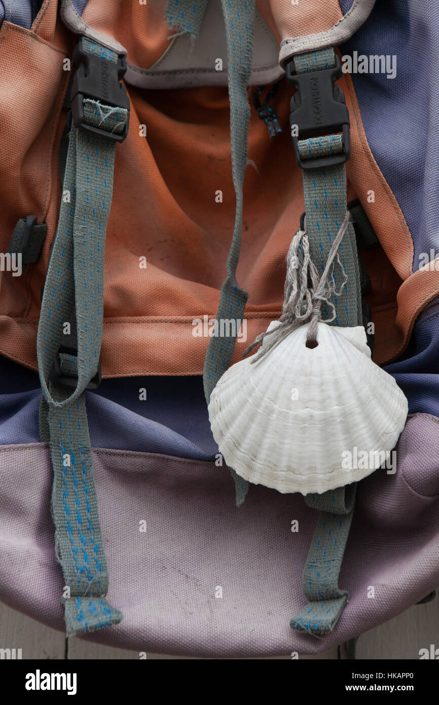 Scallop shell fixed on a pilgrim's backpack seen next to pilgrim's ...