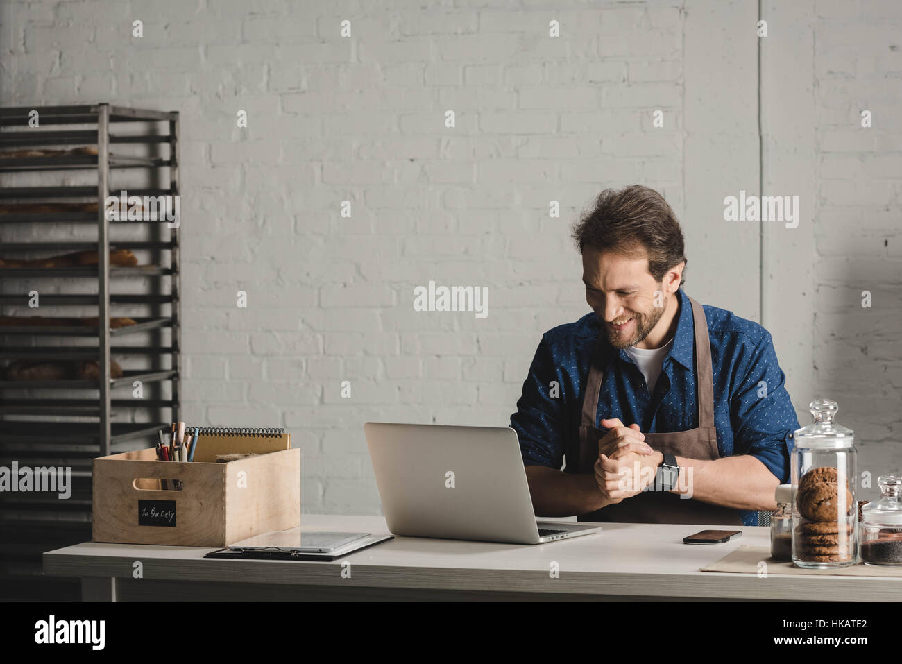 Man working with laptop at bakery Stock Photo - Alamy