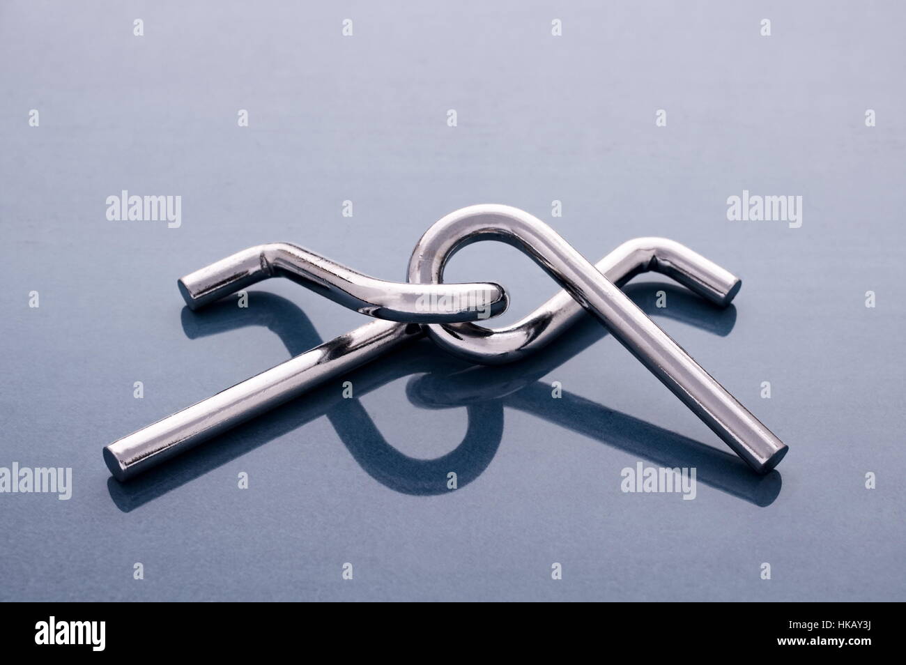 Metal puzzle mental trap on reflective gradient surface. Concept of ...