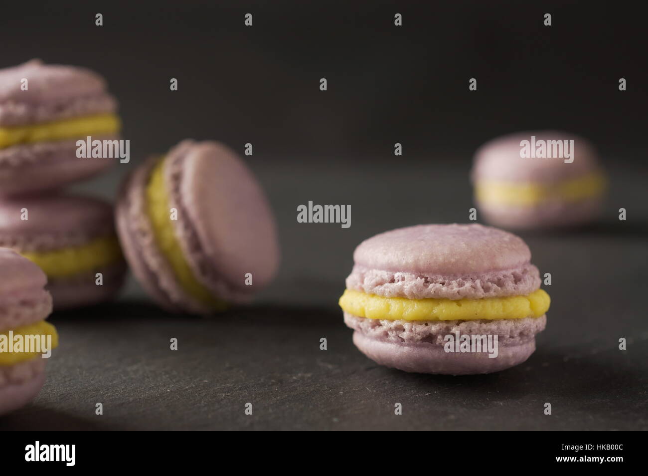 Delicious homemade lavender macaroons with vanilla cream on dark slate. Selective focus on front ...
