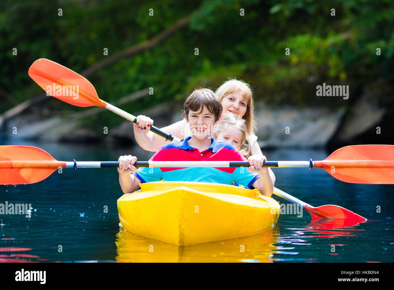 Happy family with two kids enjoying kayak ride on beautiful river ...