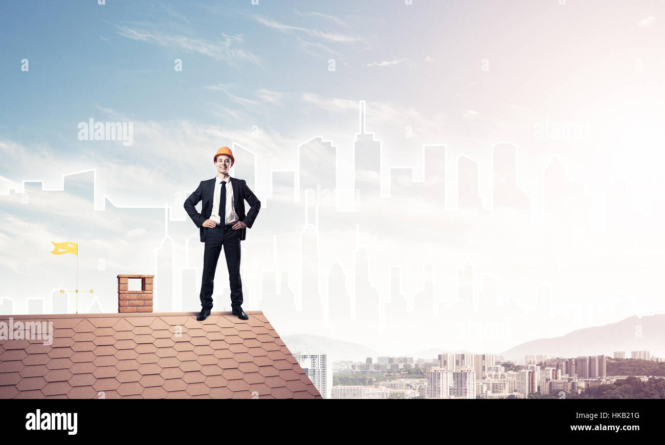 Engineer man standing on roof and looking away. Mixed media Stock Photo ...