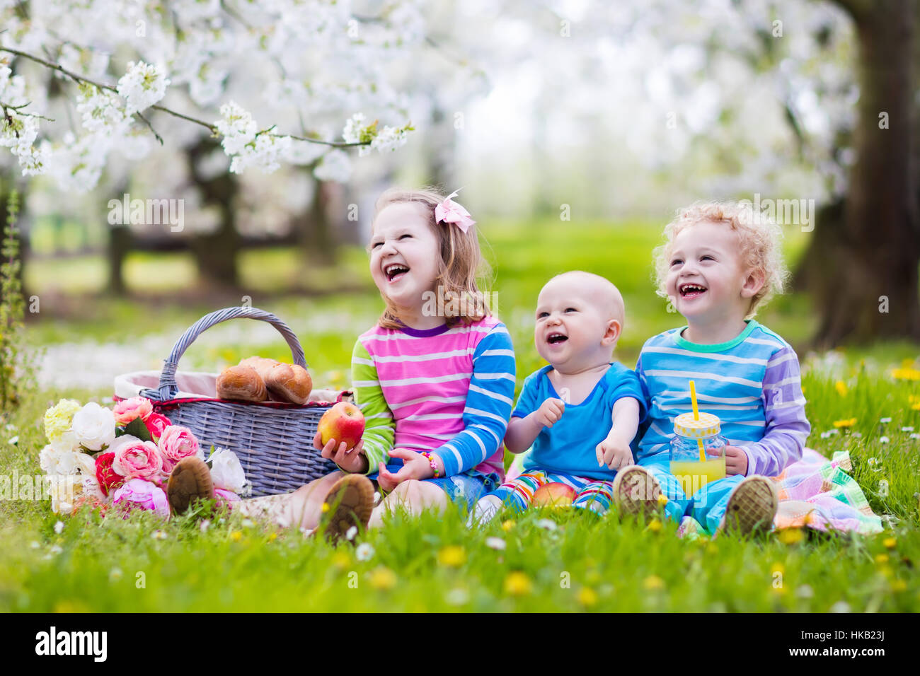 Little children eating lunch outdoors. Kids with picnic basket in ...