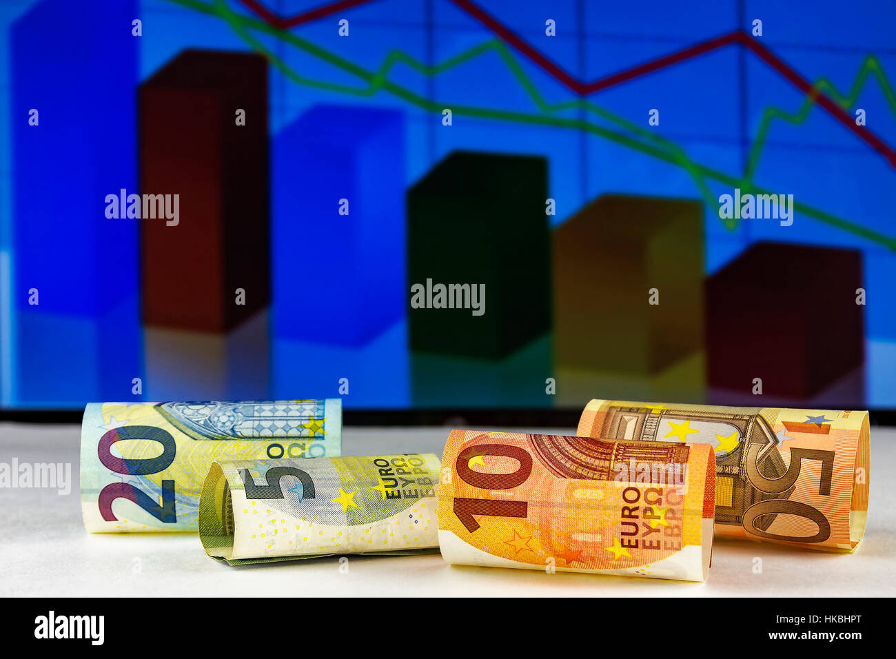 Euro banknotes are twisted into the cylinders and lie on the background ...