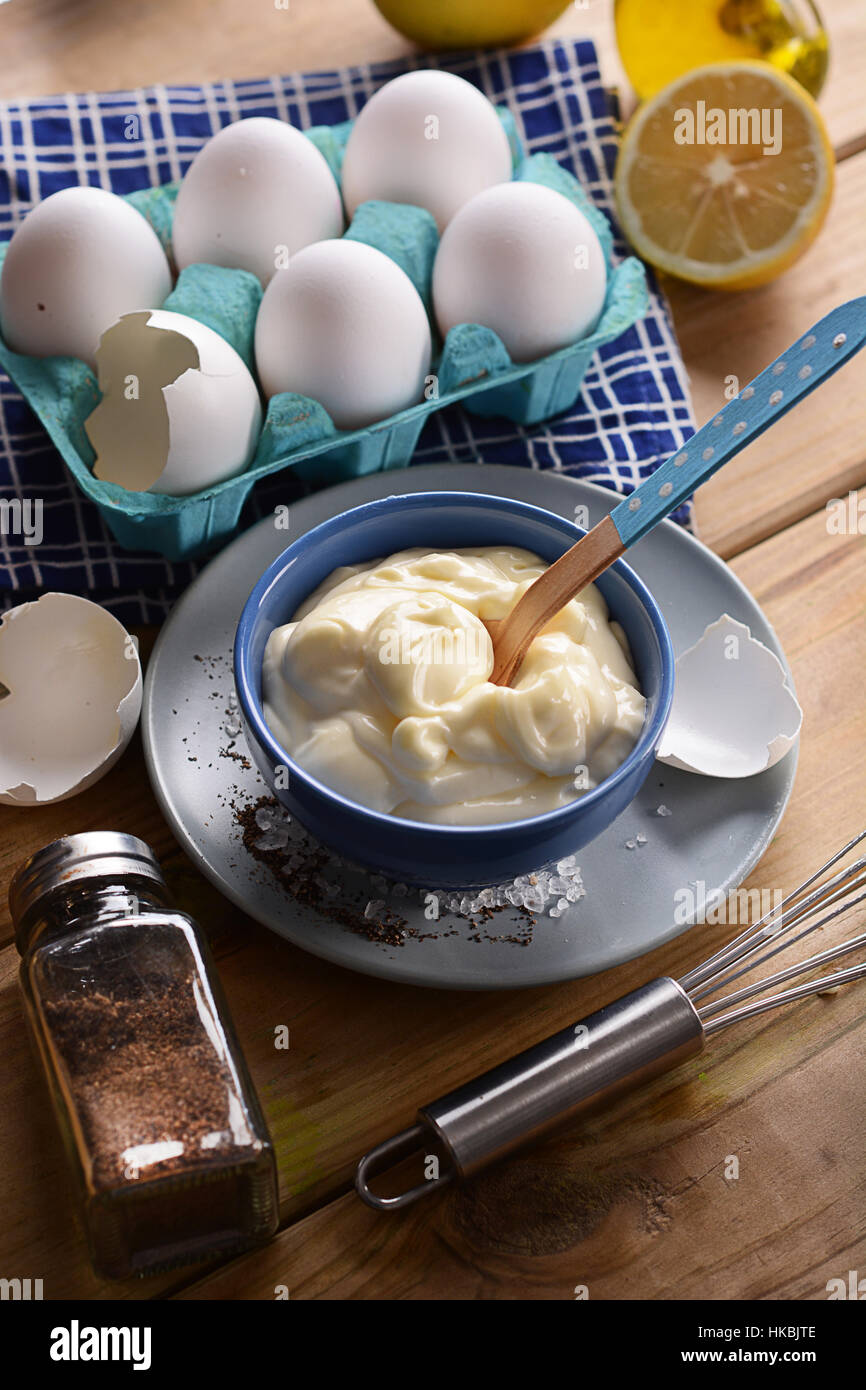 mayonnaise in blue bowl with ingredients around - traditional European ...