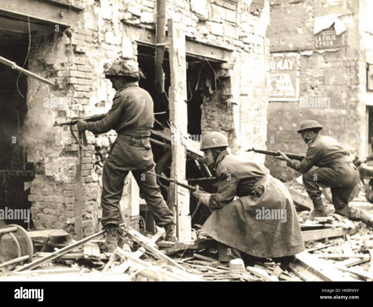 A Canadian soldier fires on the enemy in a house in Caen, July 10, 1944 ...