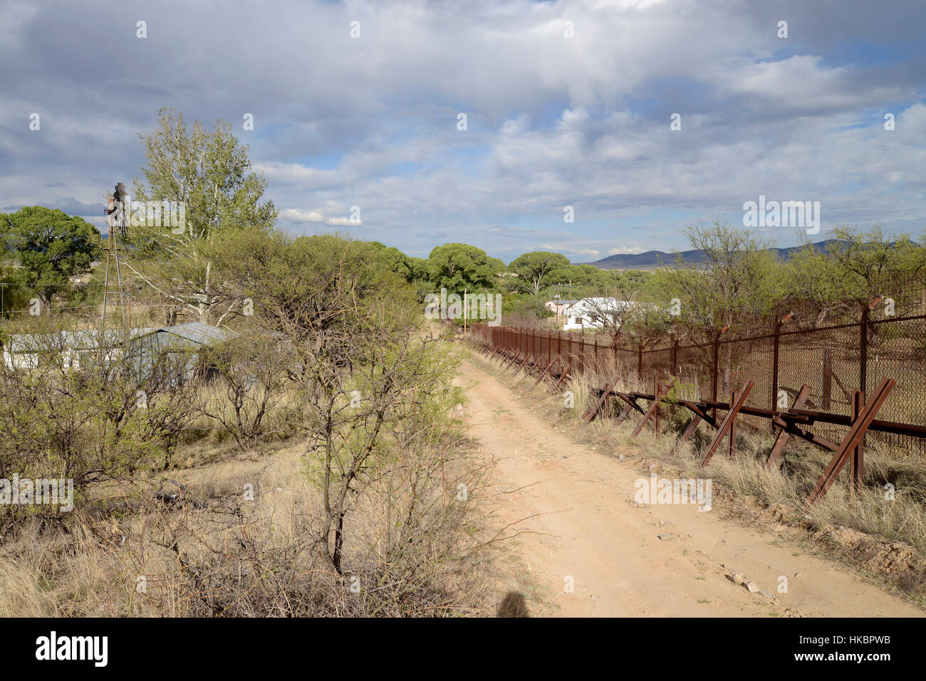 A metal wall separates houses and defines the Mexican border at Sonora ...