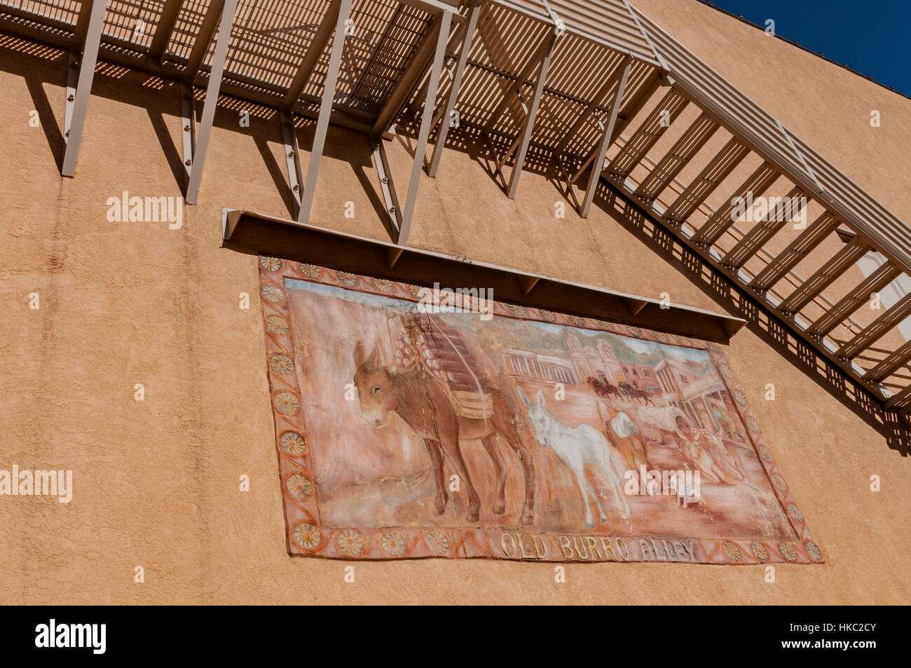 Wall with a painted mural of "Old Burro Alley" and part of a fire ...
