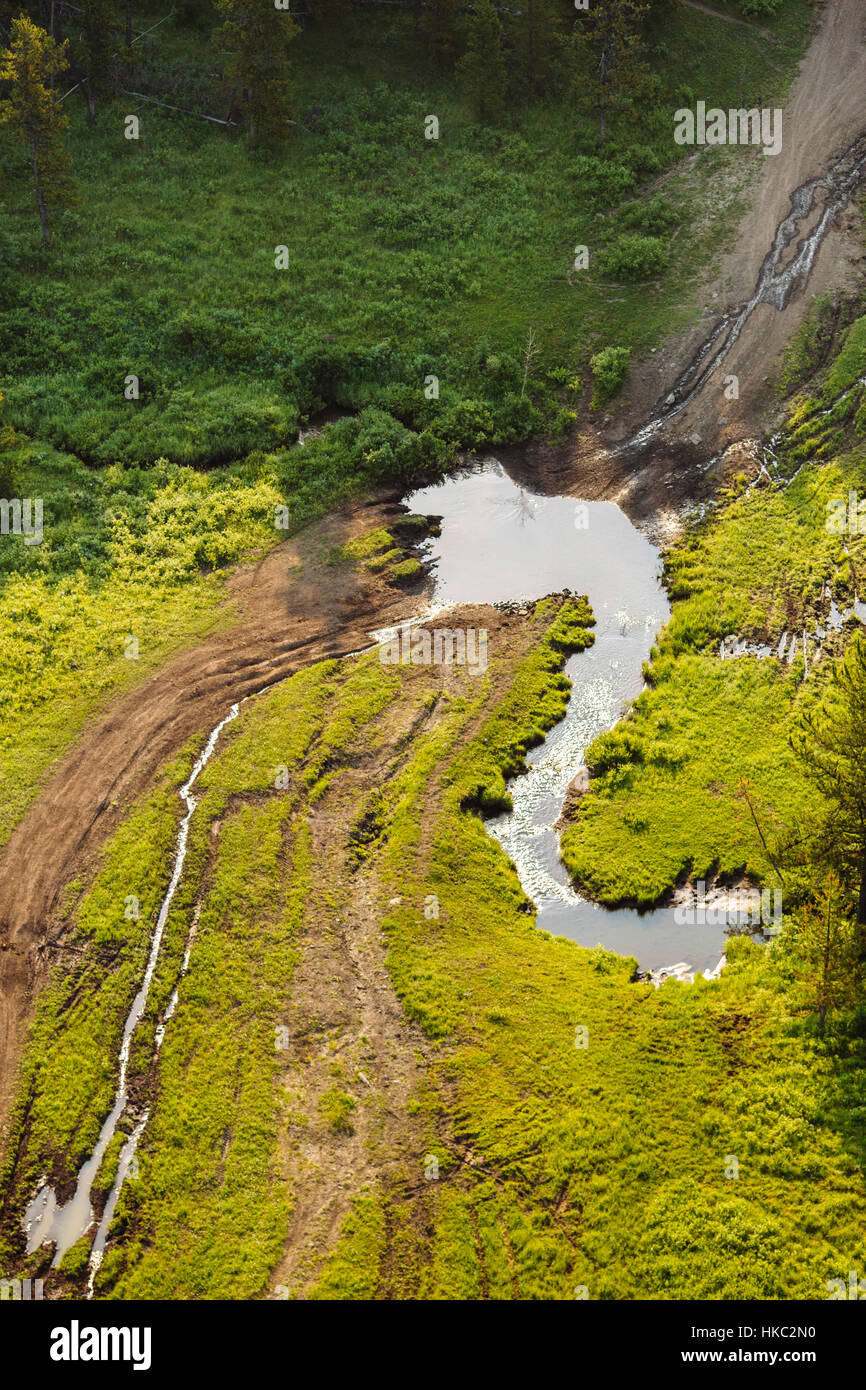 Muddy trails from OHV off road vehicles tear and track the headwater ...
