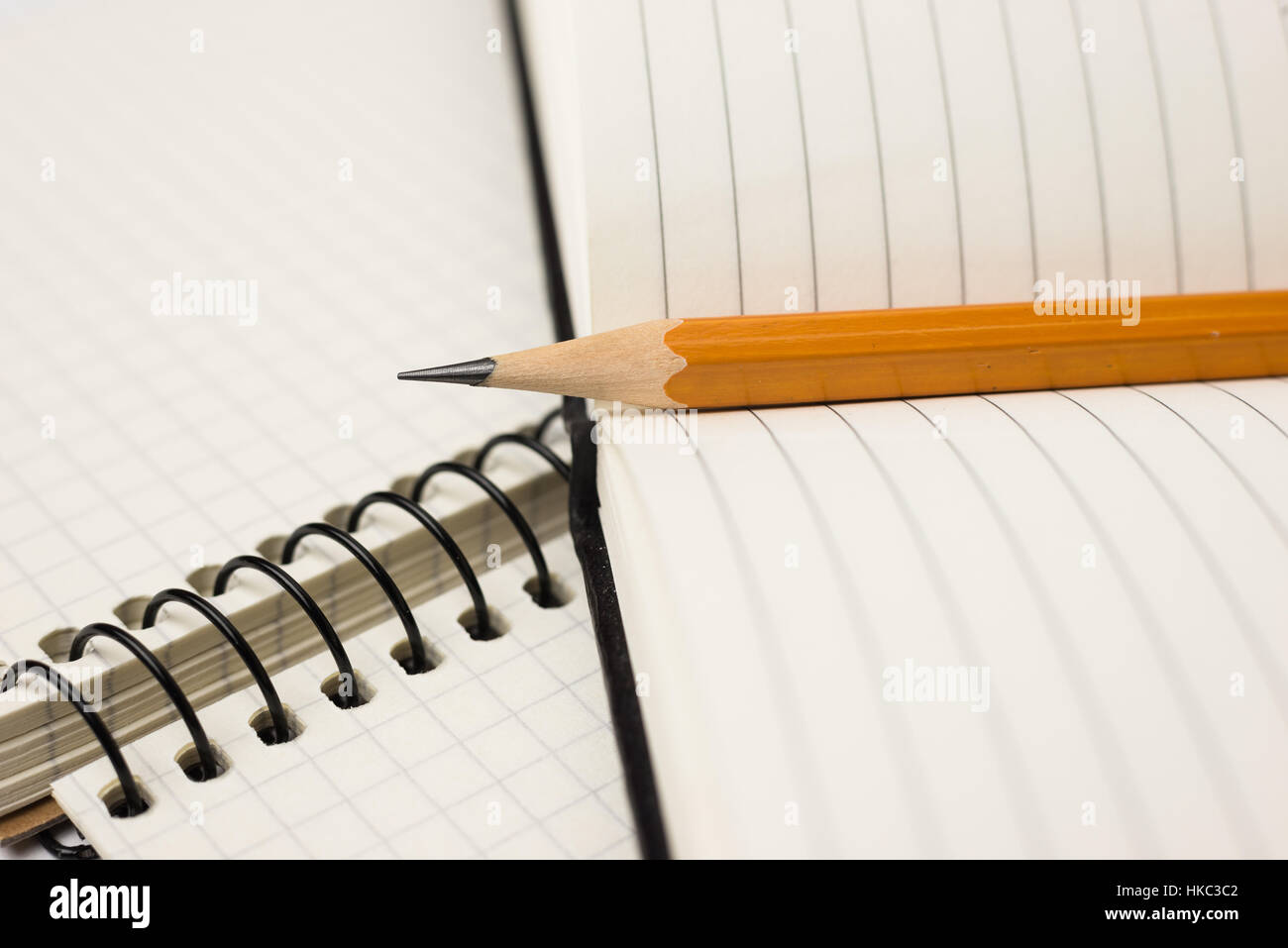 Pencil on the pages of an open notebook Stock Photo - Alamy