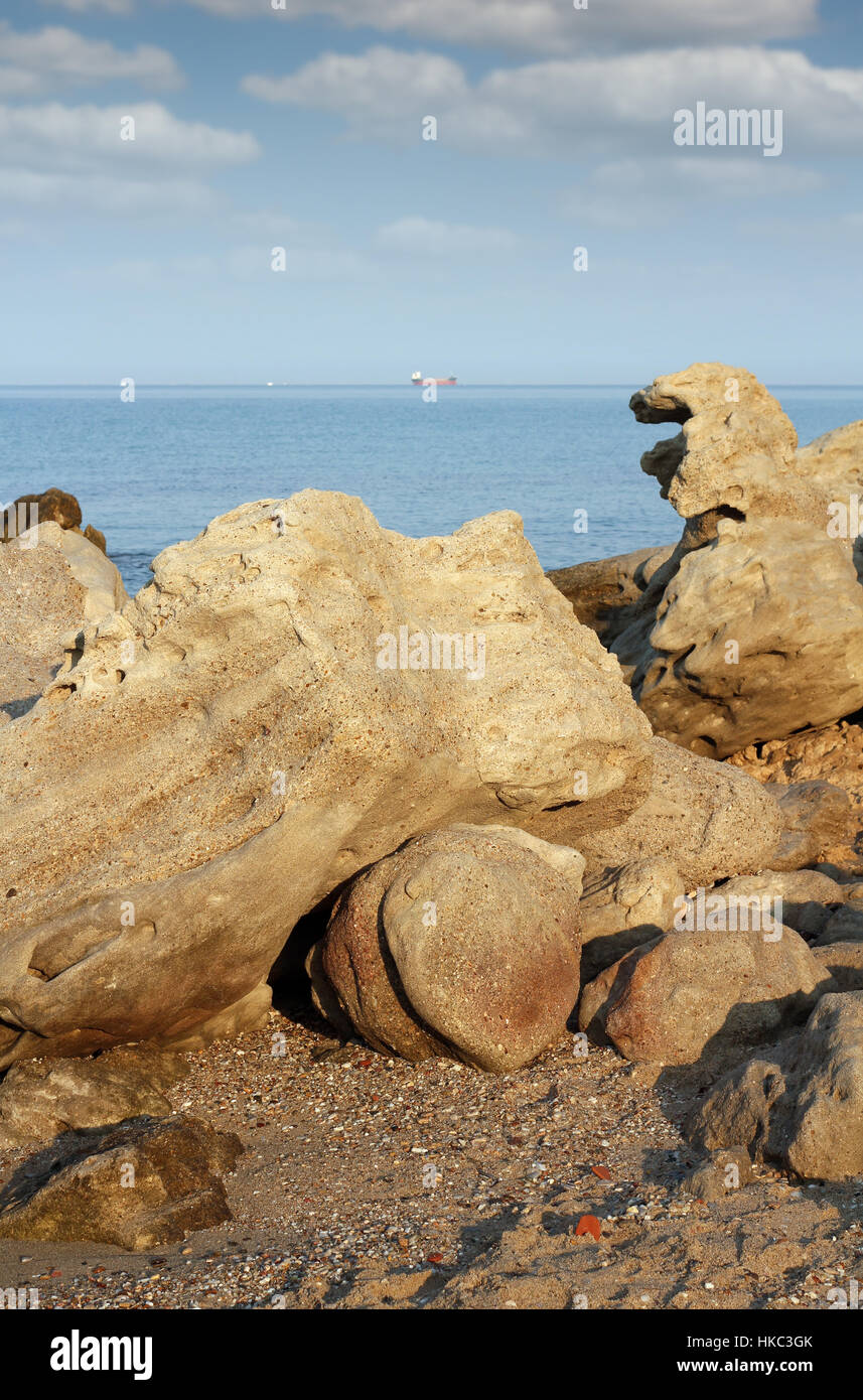 rocks on beach and ship Stock Photo - Alamy