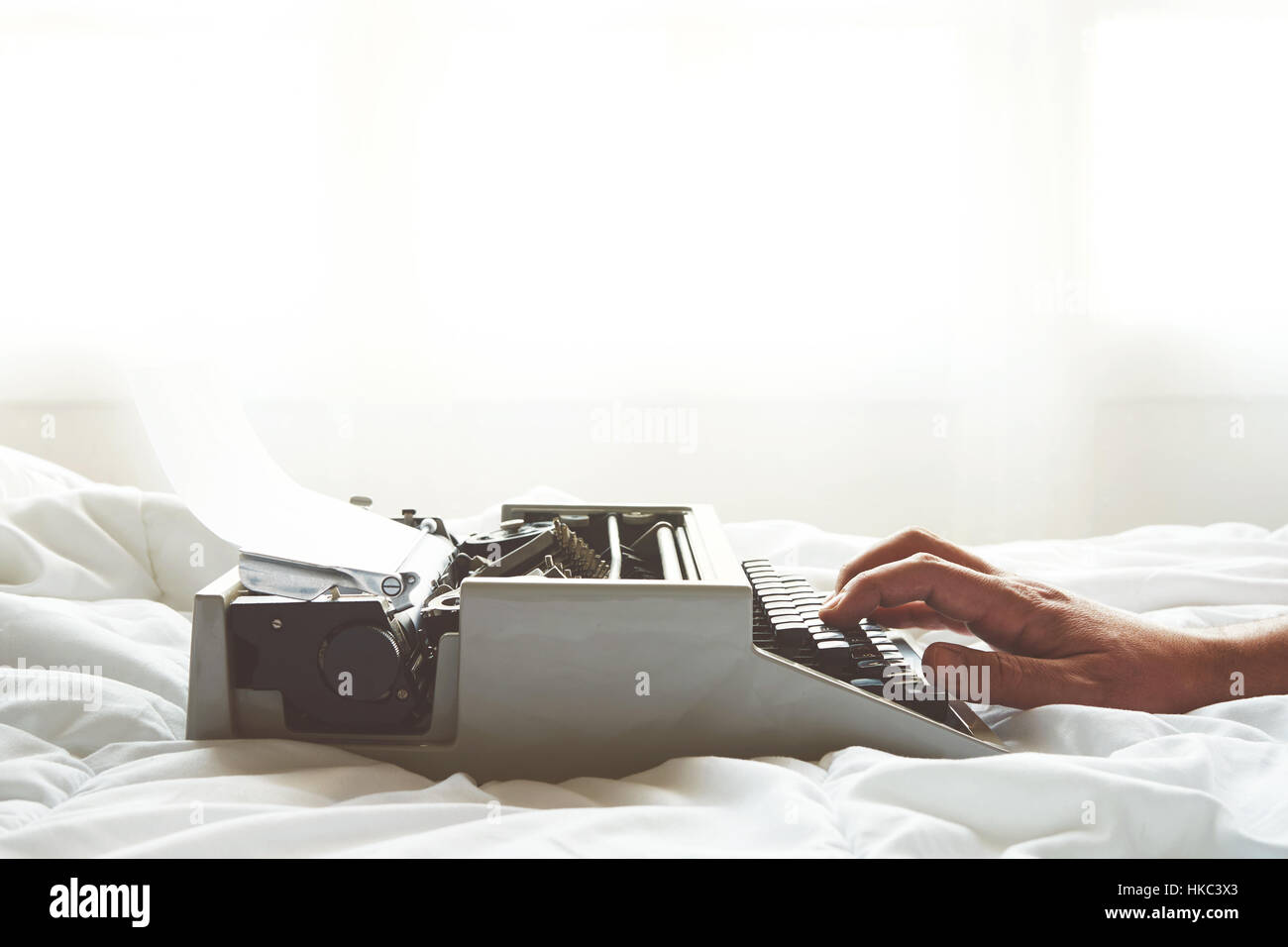Men hands typing on vintage typewriter on the bed Stock Photo - Alamy