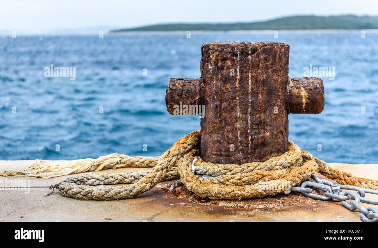 Old rusty steel mooring bollard pole on a pier. The best way for boat ...