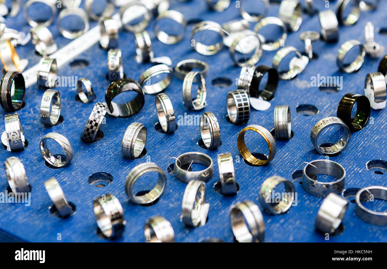 Display with different designs of handmade silver rings on blue stand ...